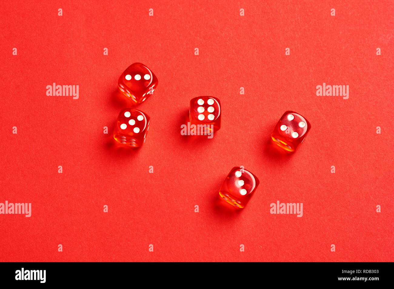 five red dice view from above on red background Stock Photo - Alamy