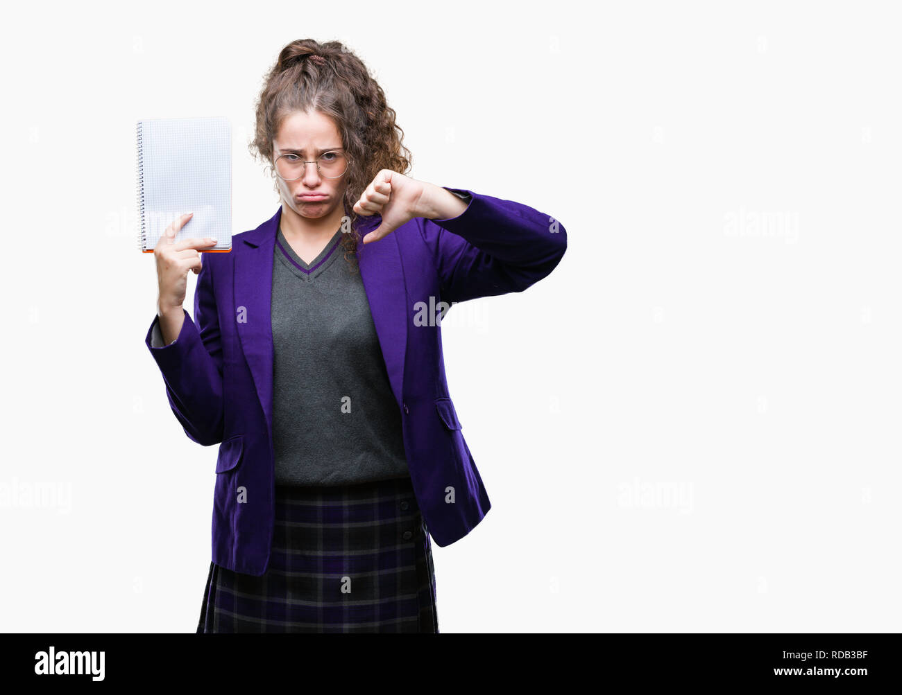 Young brunette student girl wearing school uniform holding a notebook ...