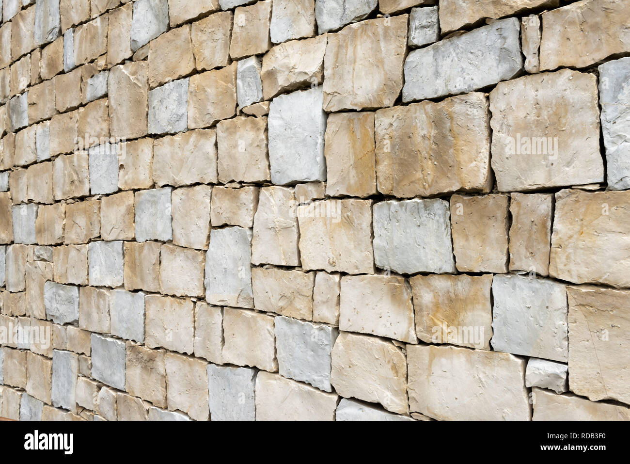 Light warm yellow sandstone wall made of square blocks seen in ...