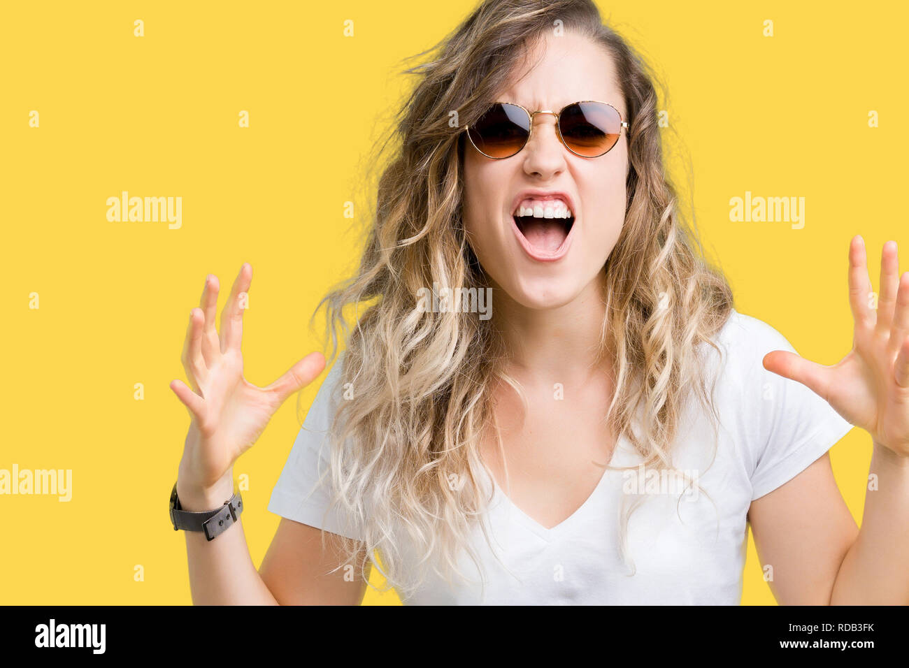 Beautiful young blonde woman wearing sunglasses over isolated ...