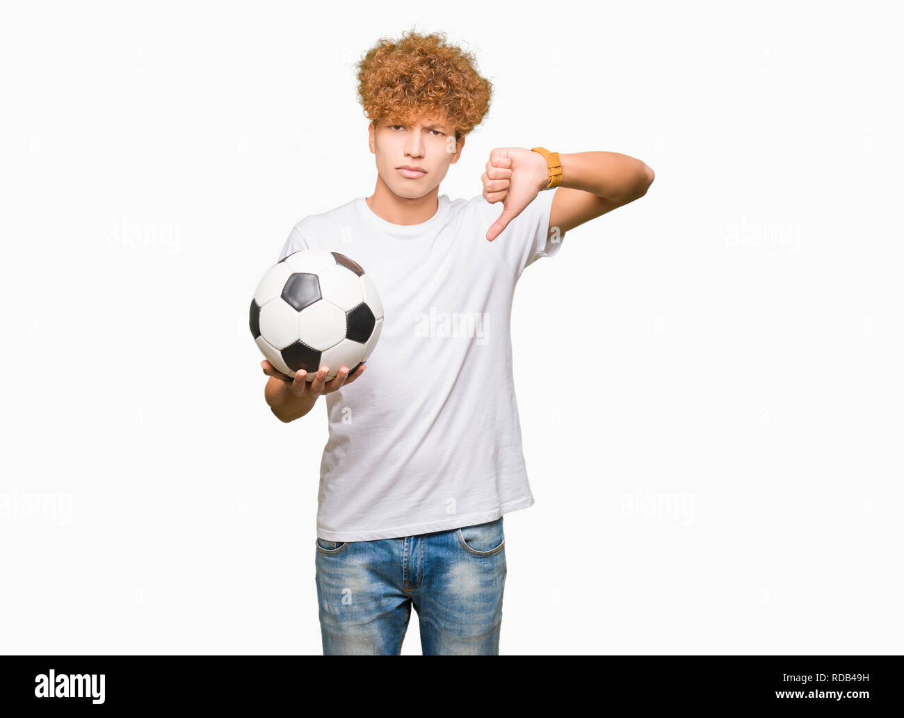 Young handsome man holding soccer football ball with angry face ...