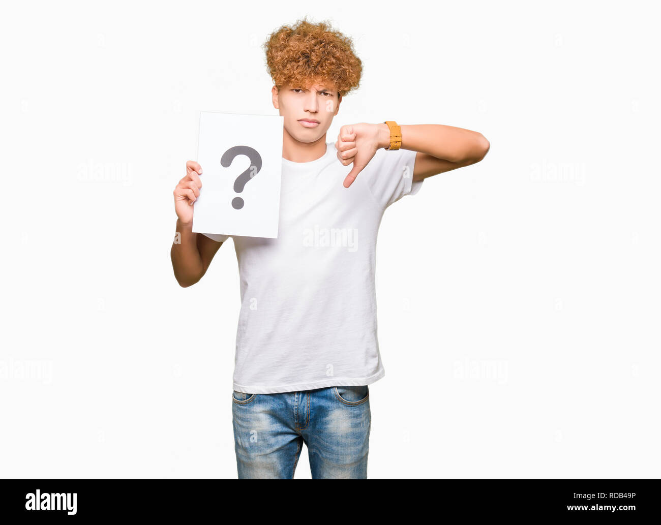 Young handsome man holding paper with question mark with angry face ...