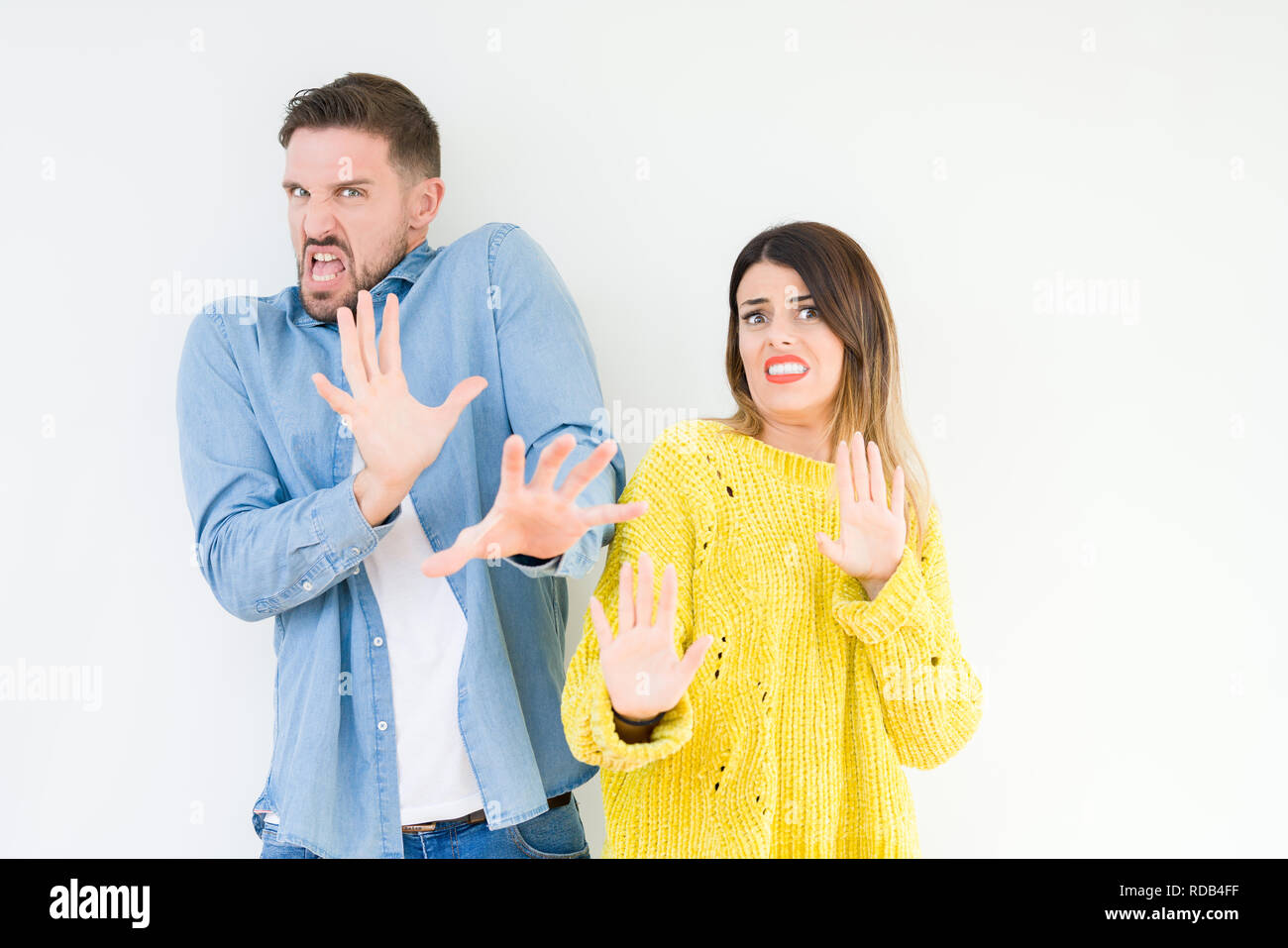 Young beautiful couple togheter over isolated background afraid and ...