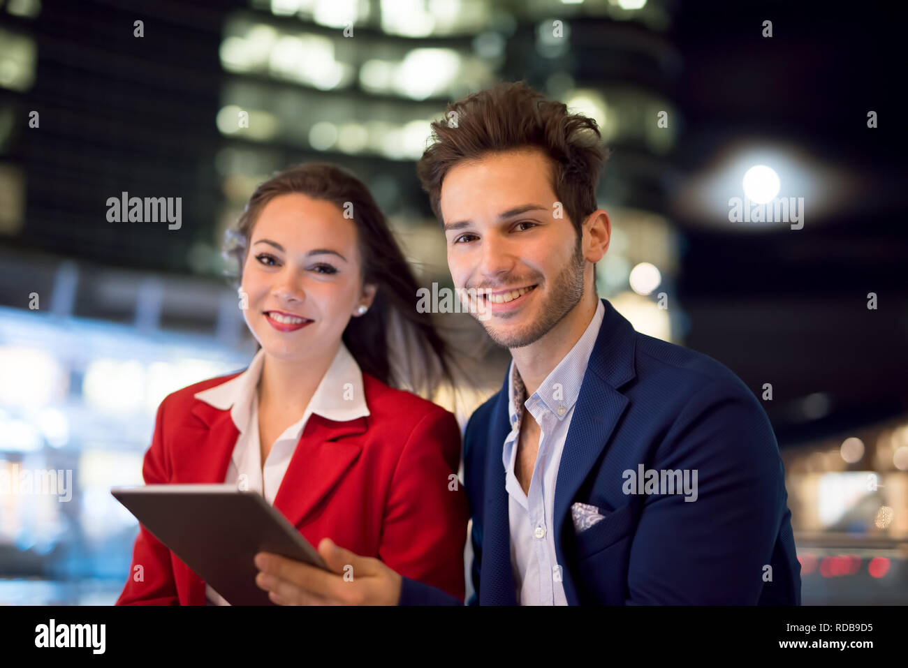 People using tablet at night in a city Stock Photo - Alamy