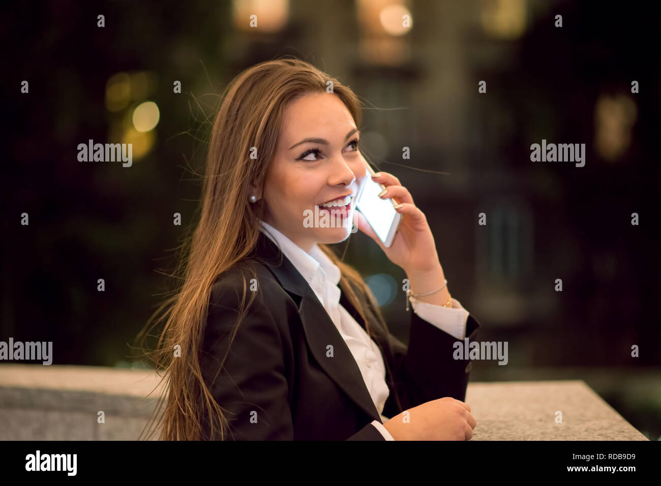 Woman talking on her mobile phone at night Stock Photo - Alamy