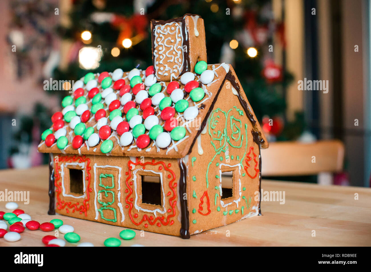 Gingerbread fairy house on a background of bright Christmas tree with ...