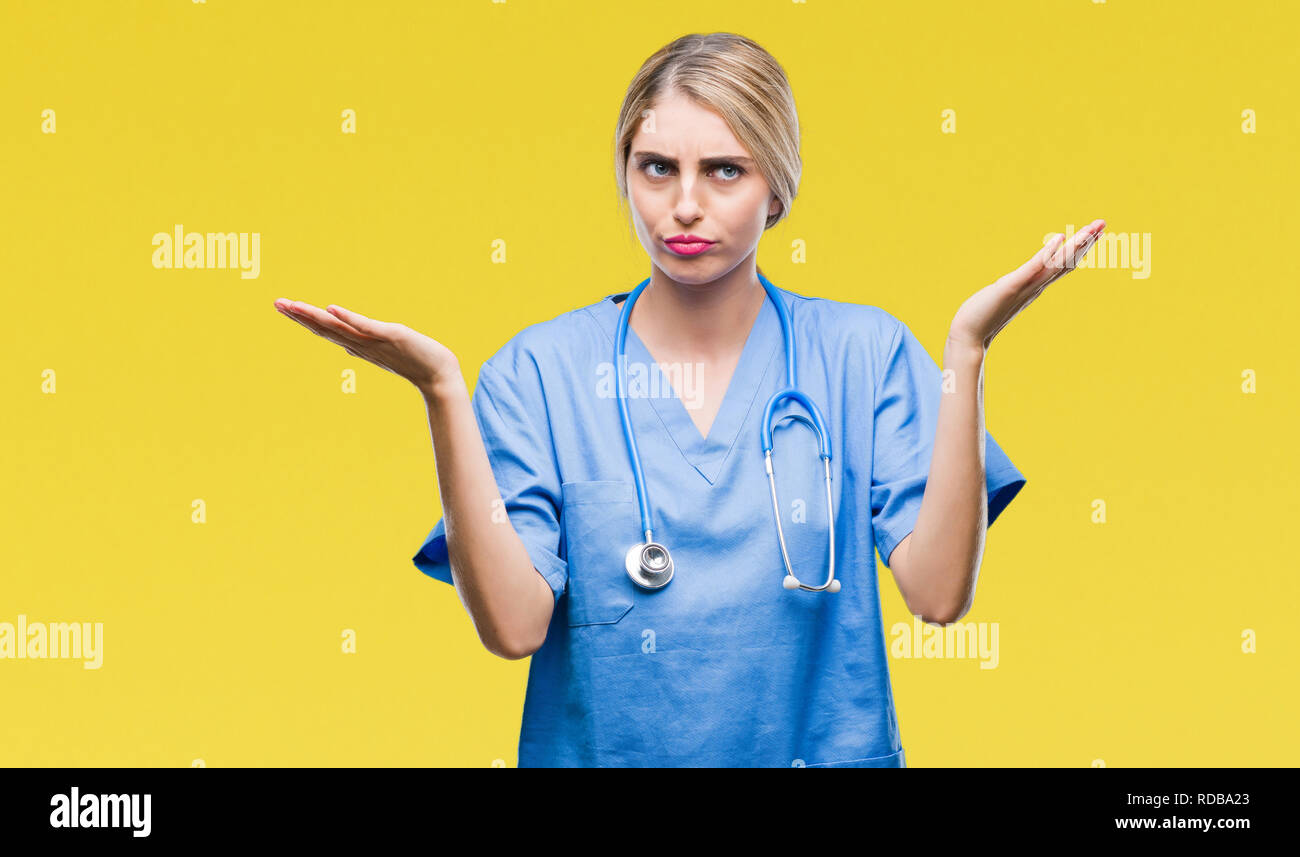 Young beautiful blonde doctor surgeon nurse woman over isolated ...