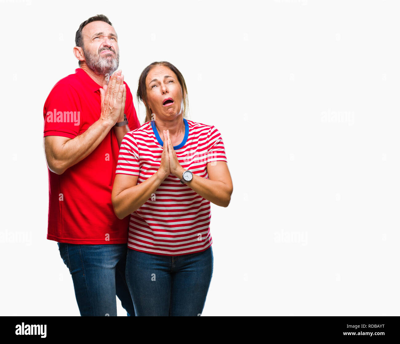 Middle age hispanic couple in love over isolated background begging and ...