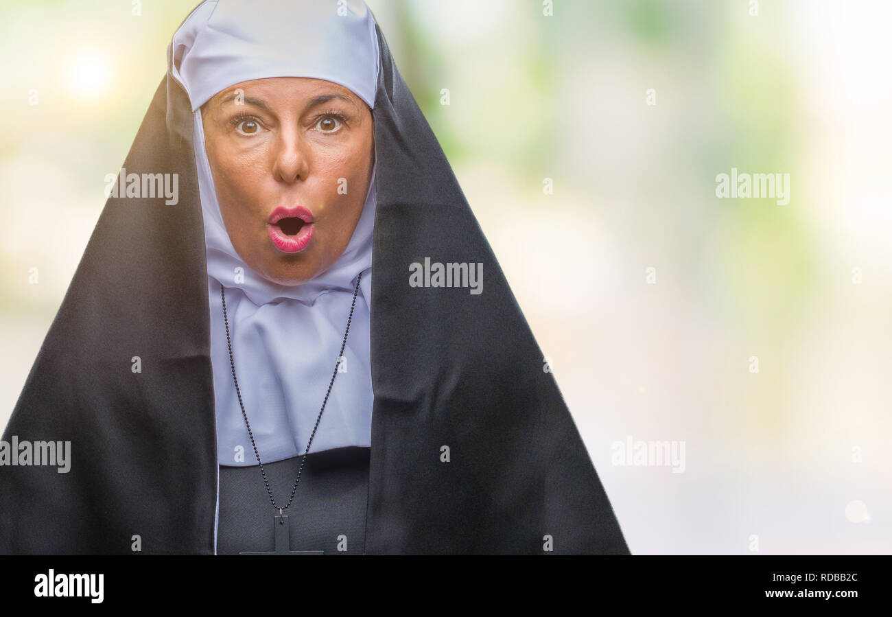 Middle age senior christian catholic nun woman over isolated background ...