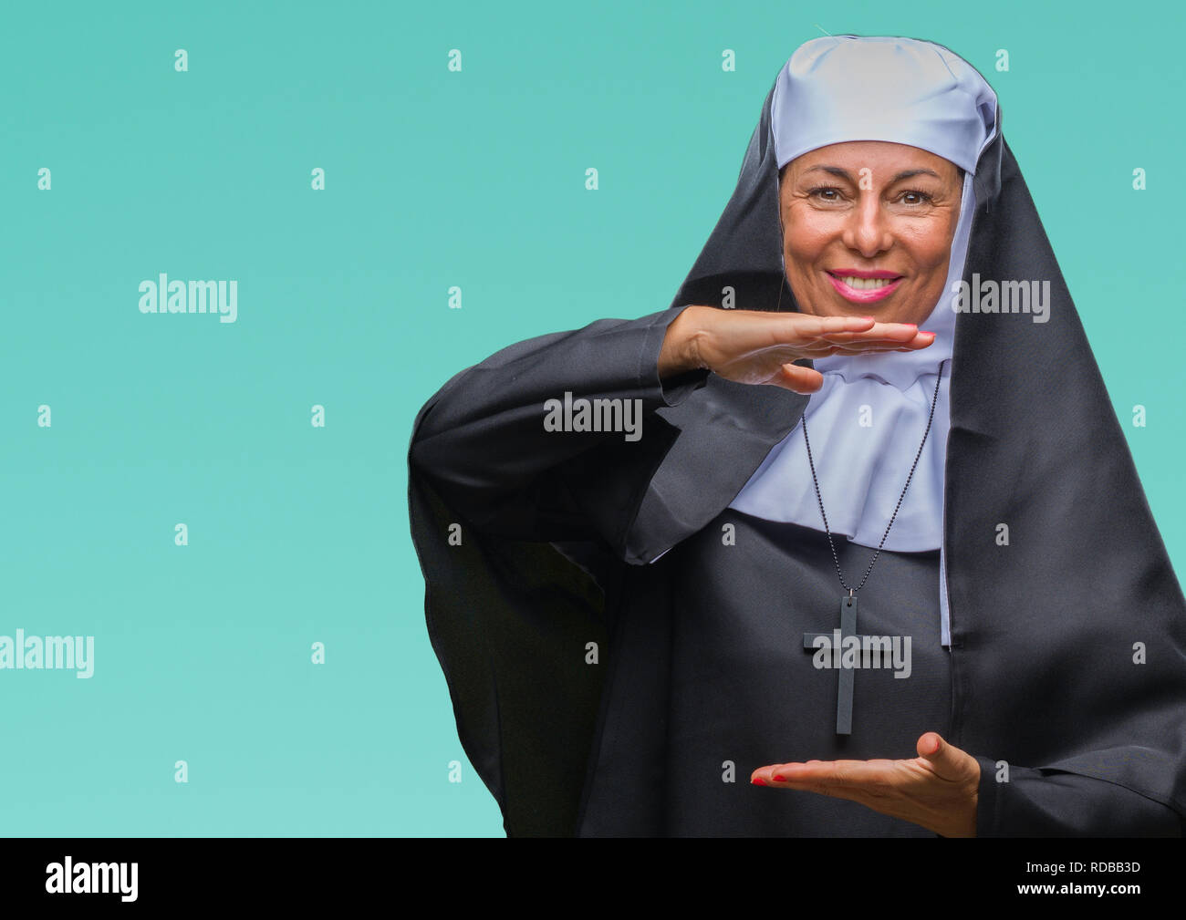 Middle age senior christian catholic nun woman over isolated background ...
