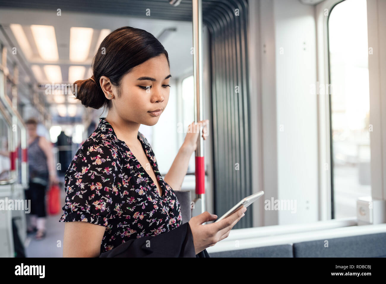 Young Asian student reading texts while riding the train Stock Photo ...