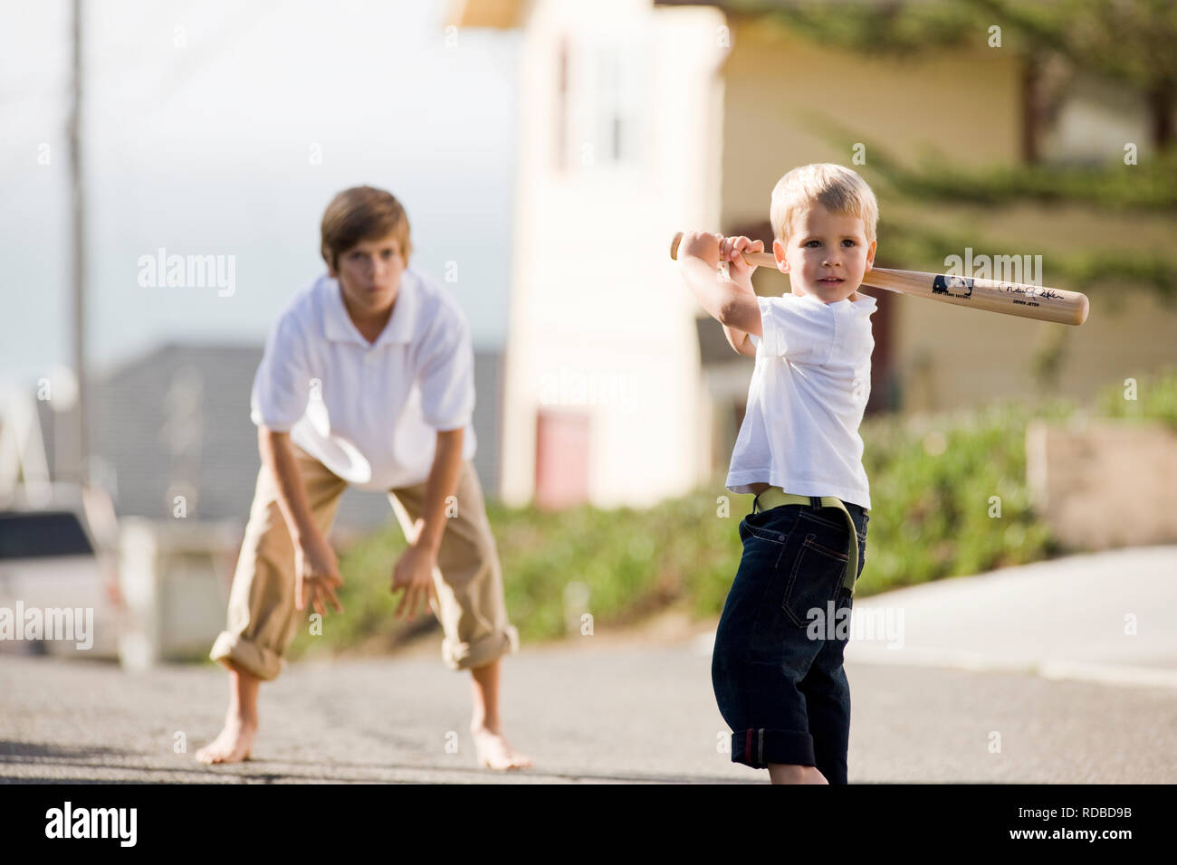 Brothers playing baseball on the street Stock Photo - Alamy