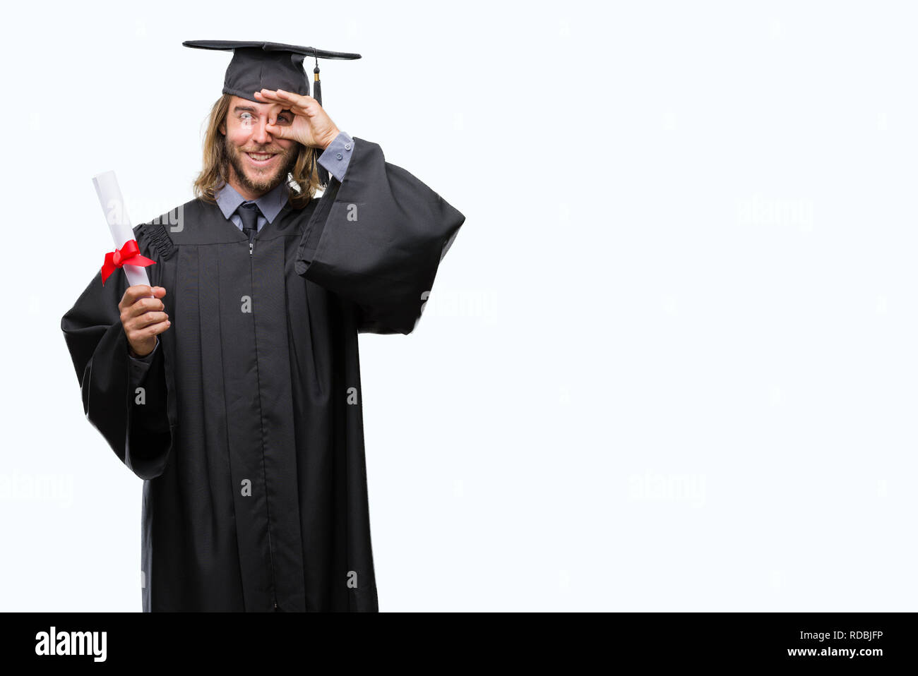 Young handsome graduate man with long hair holding degree over isolated ...