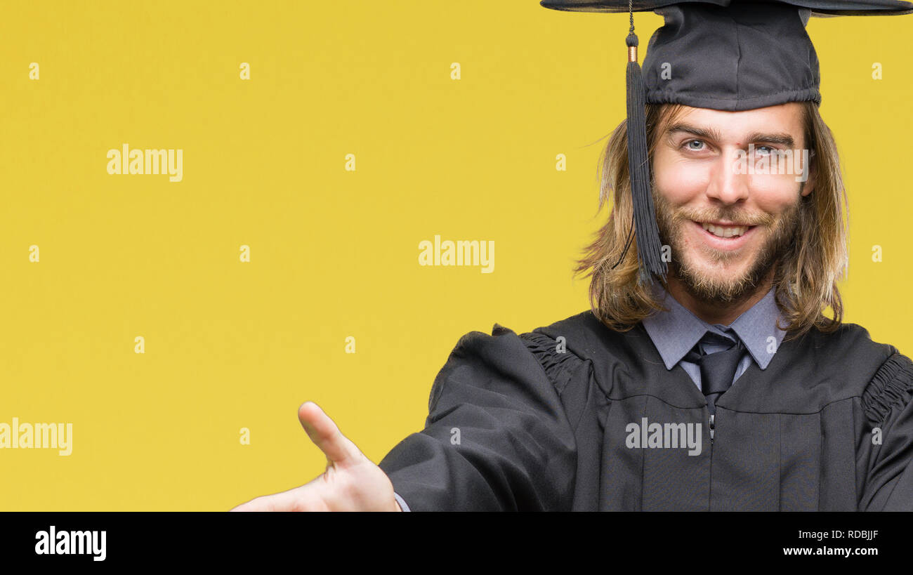 Young handsome graduated man with long hair over isolated background ...
