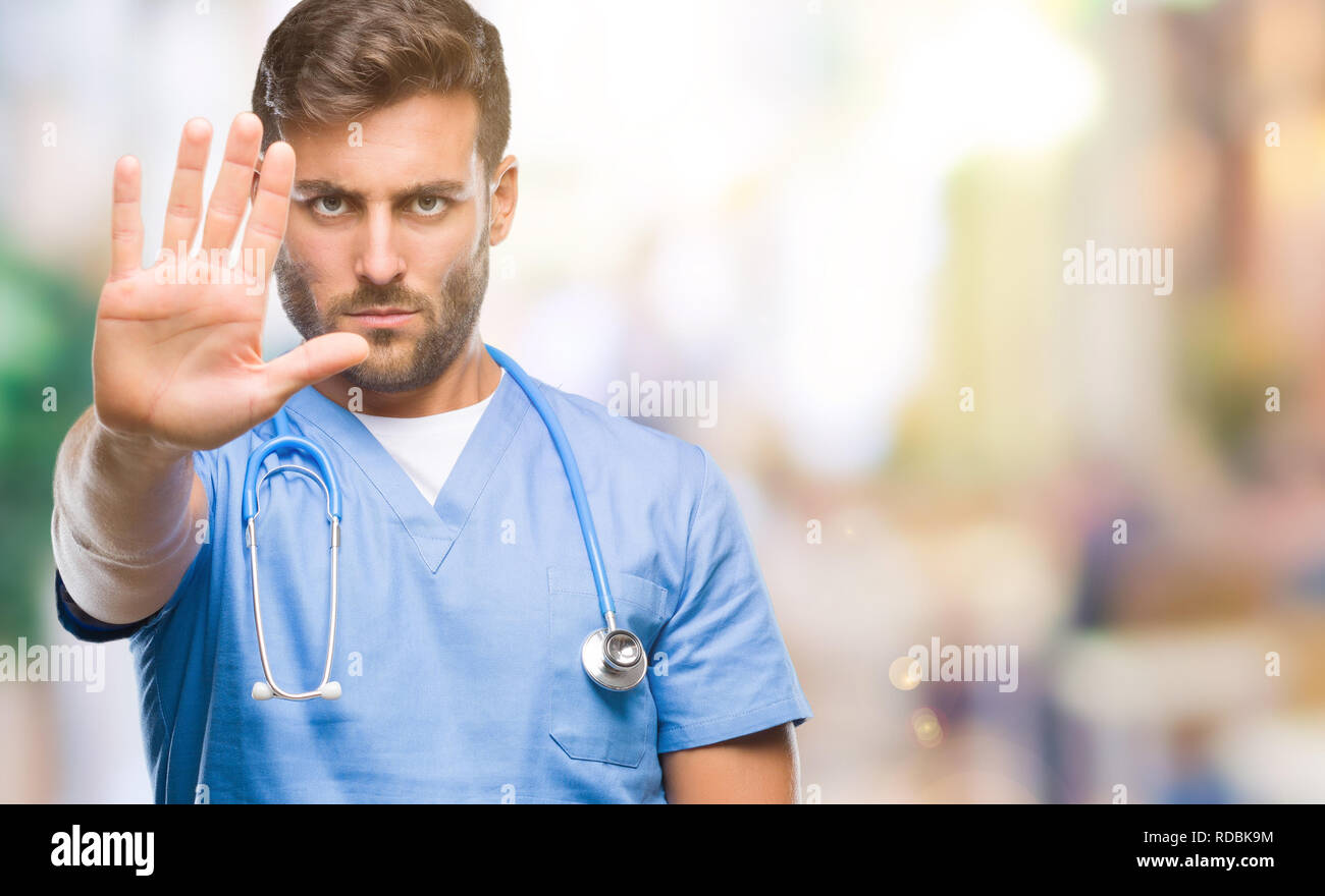 Young handsome doctor surgeon man over isolated background doing stop ...