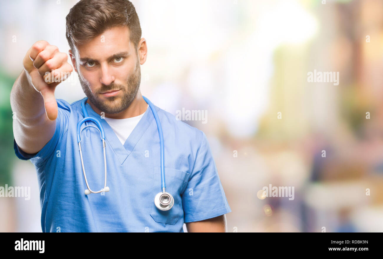 Young handsome doctor surgeon man over isolated background looking ...