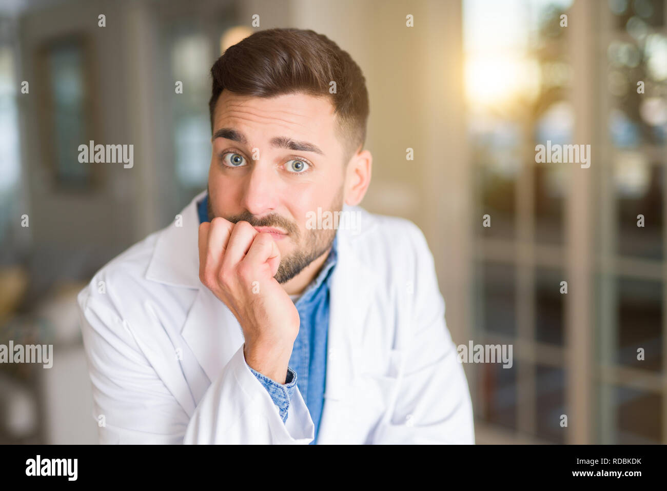 Young handsome doctor man at the clinic thinking looking tired and ...