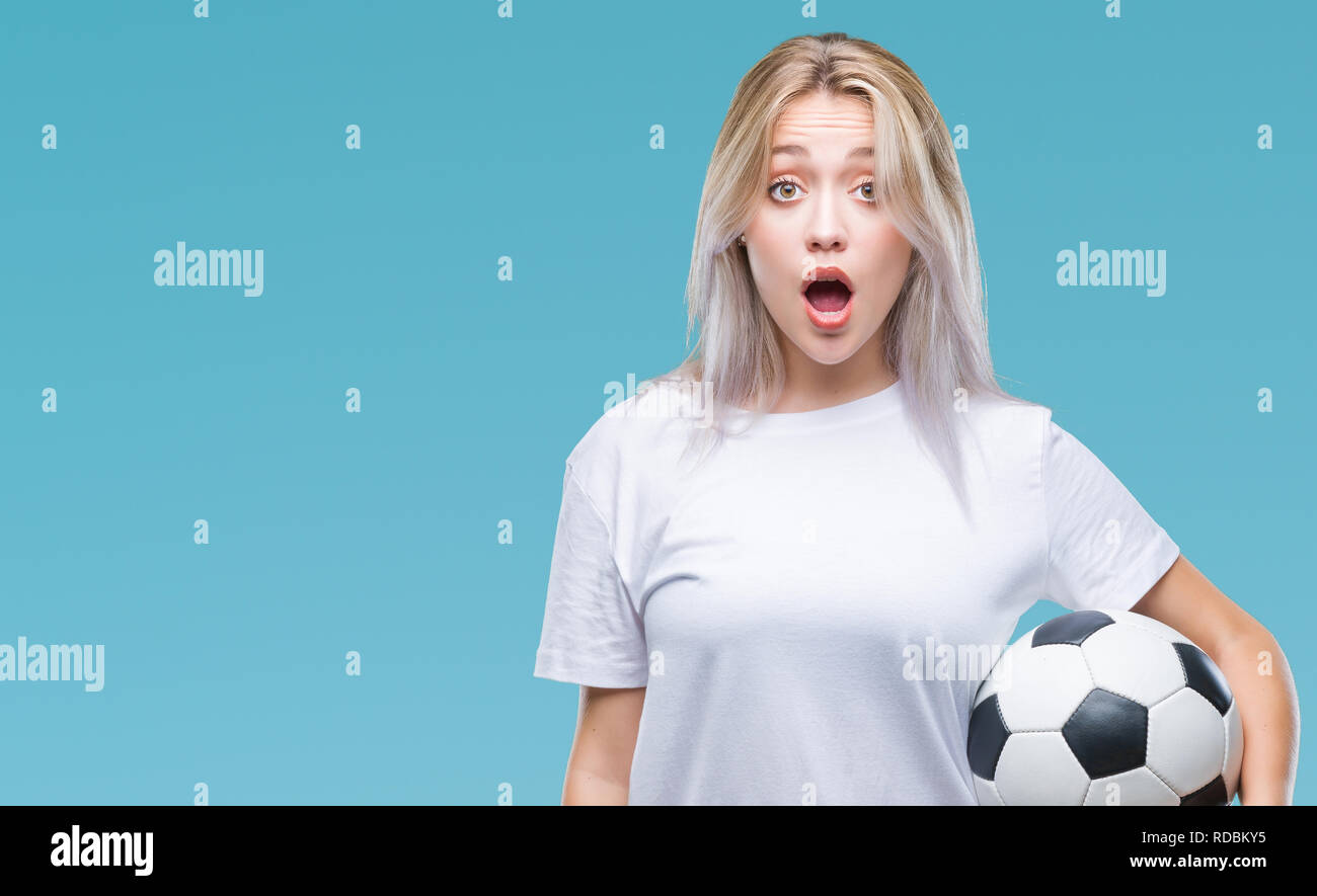 Young blonde woman holding soccer football ball over isolated ...