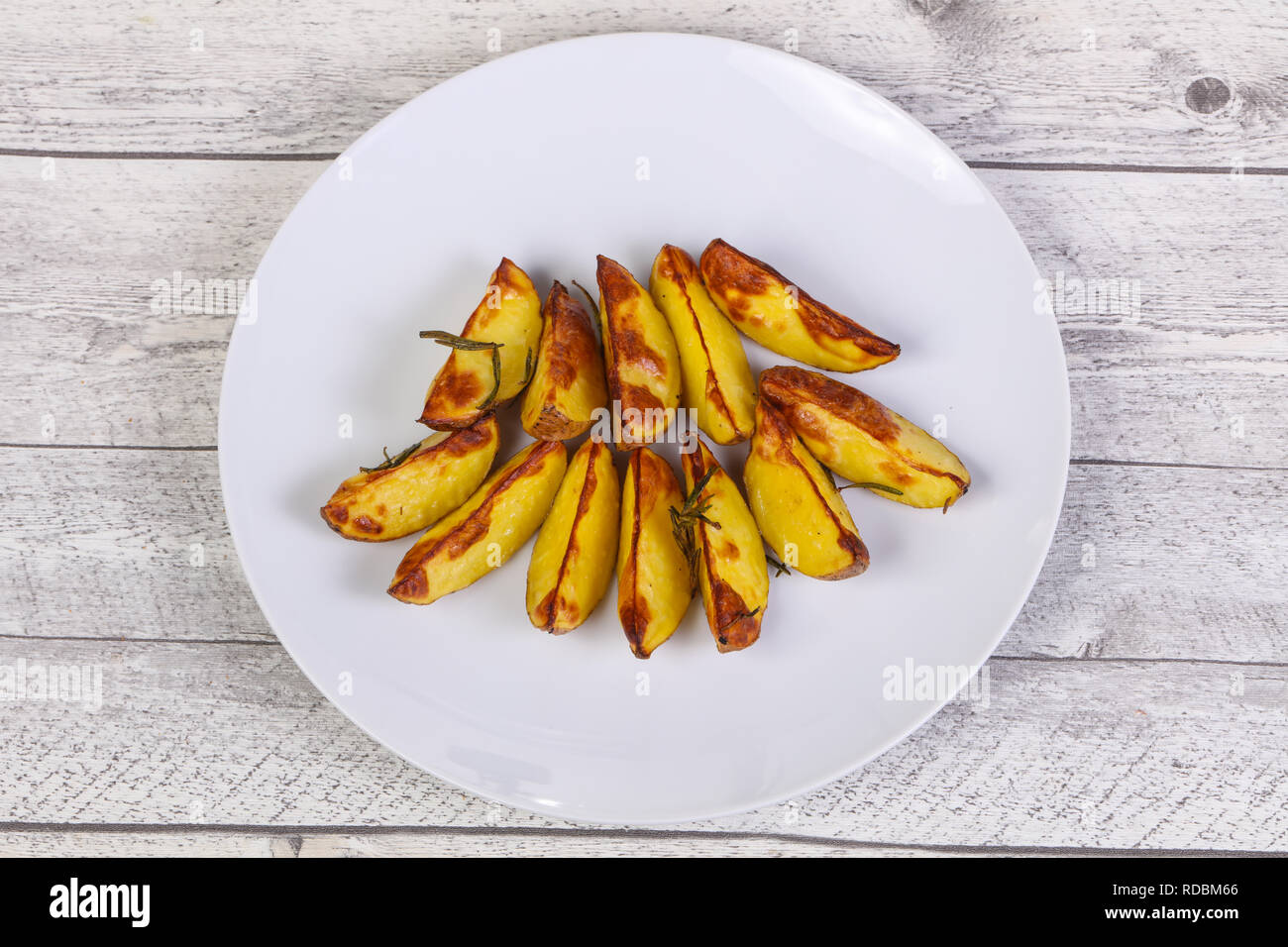 Baked potato pieces with rosemary Stock Photo - Alamy