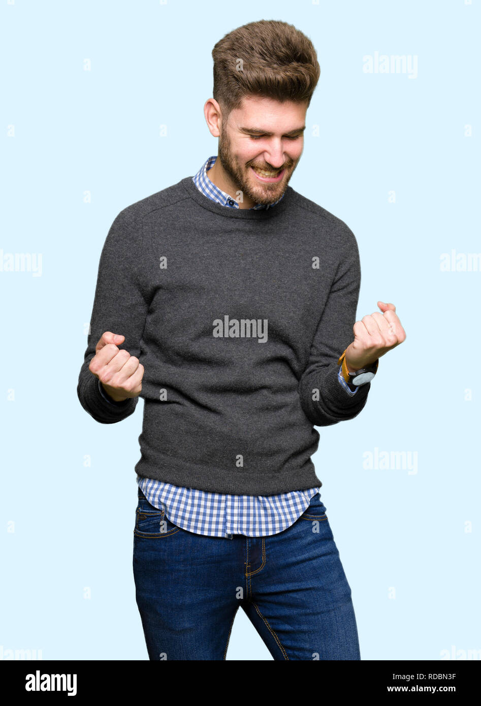 Young handsome elegant man very happy and excited doing winner gesture ...