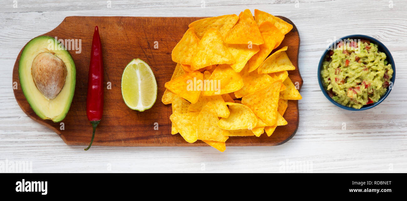 Bowl of traditional mexican guacamole and ingredients with nachos on ...