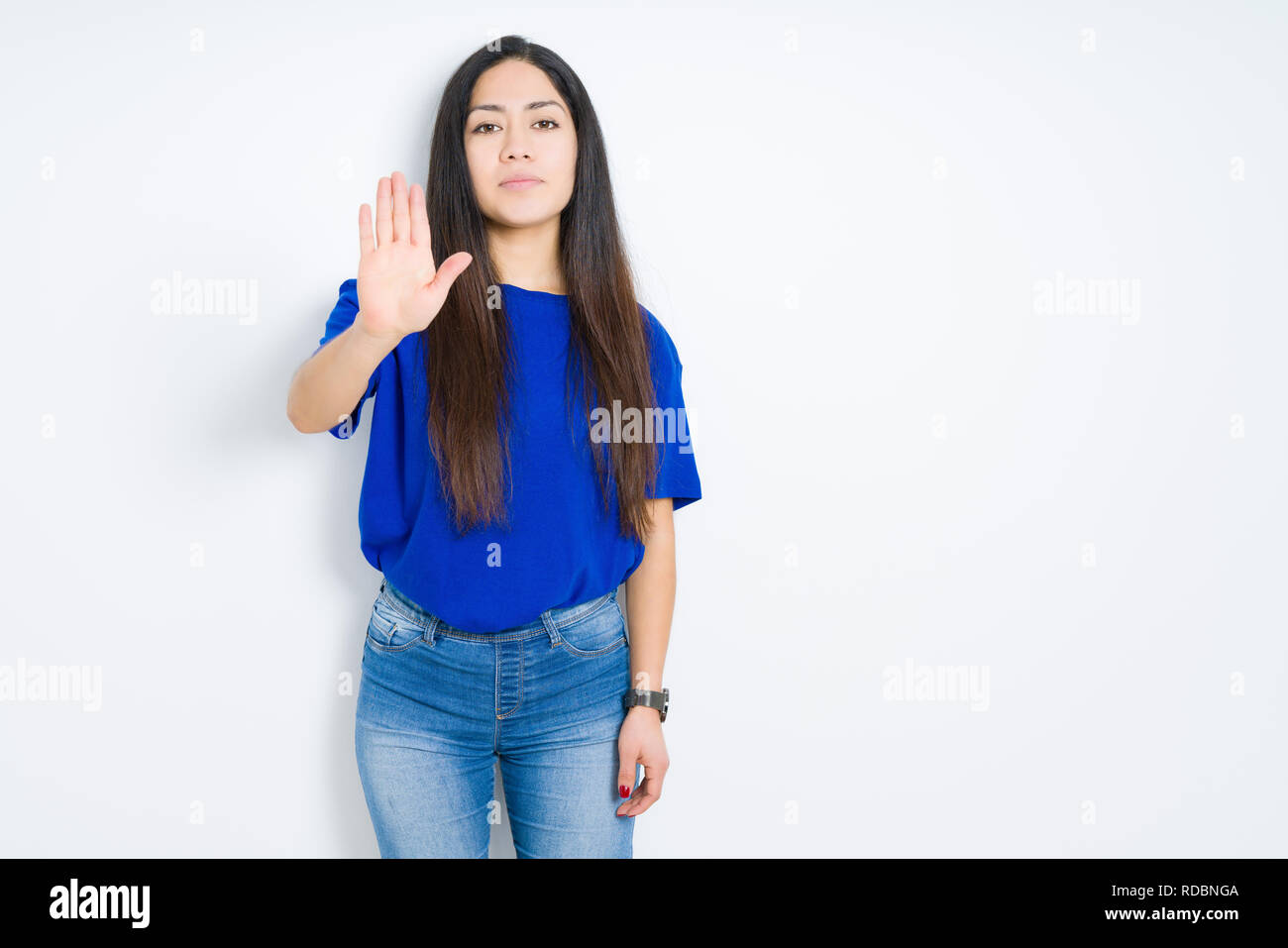 Beautiful brunette woman over isolated background doing stop sing with ...