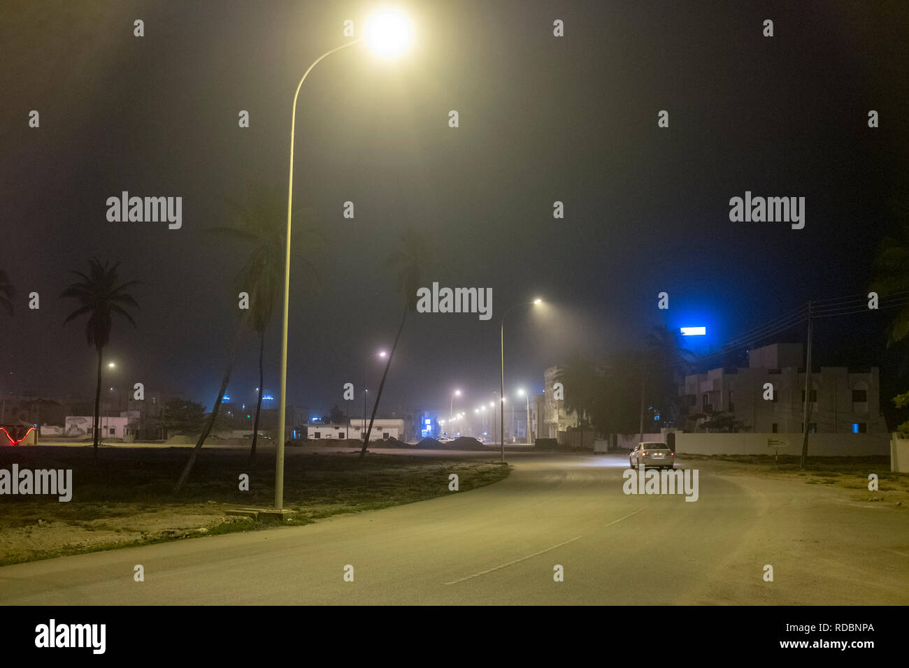 Bright streetlights illuminating quiet suburban road in Salalah ...