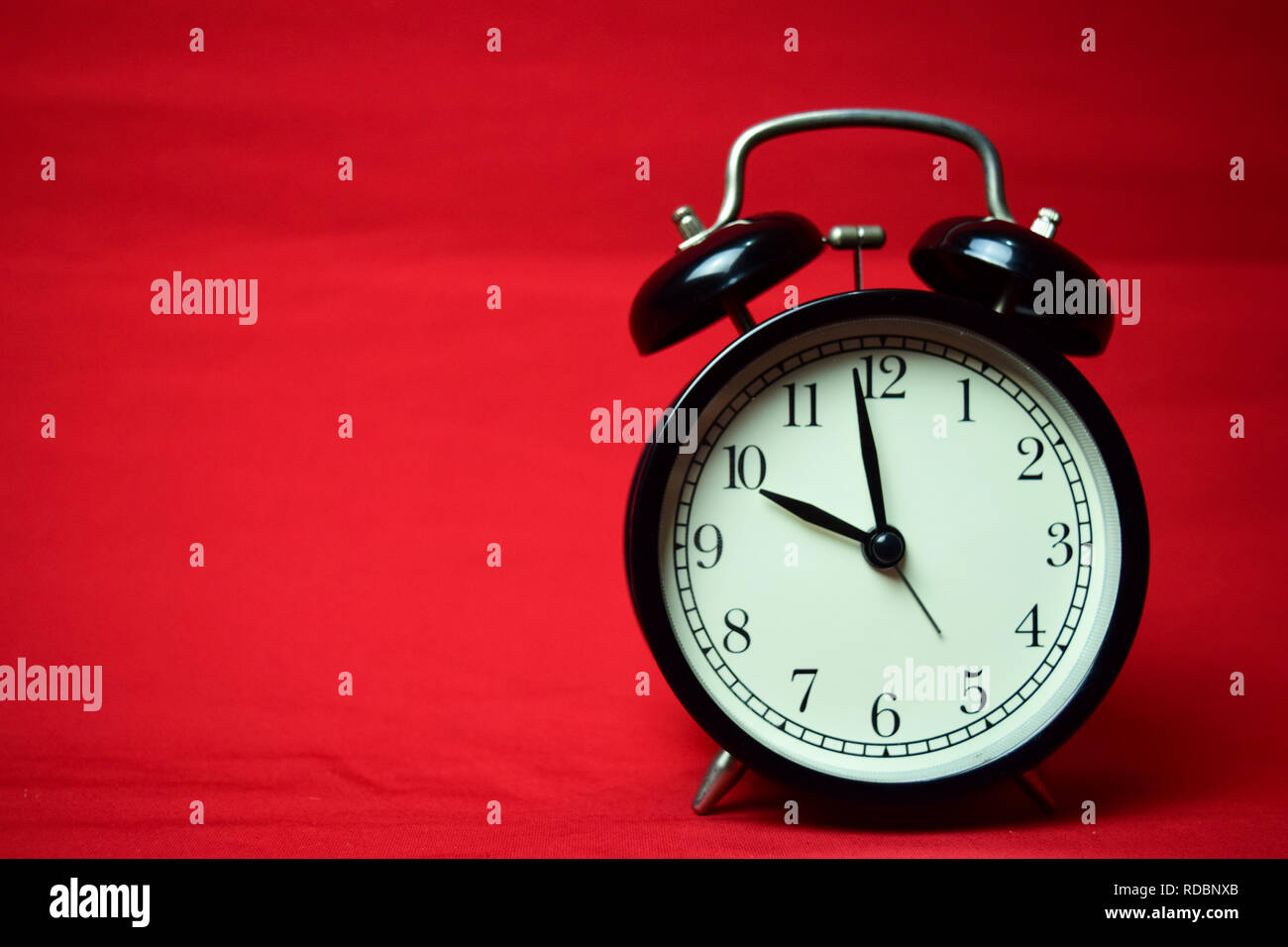Clock ticking to 10 o'clock on the red background Stock Photo - Alamy