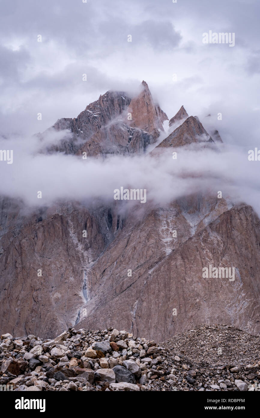 Majestic peak of beautiful Trango Towers surrounded by white clouds in ...