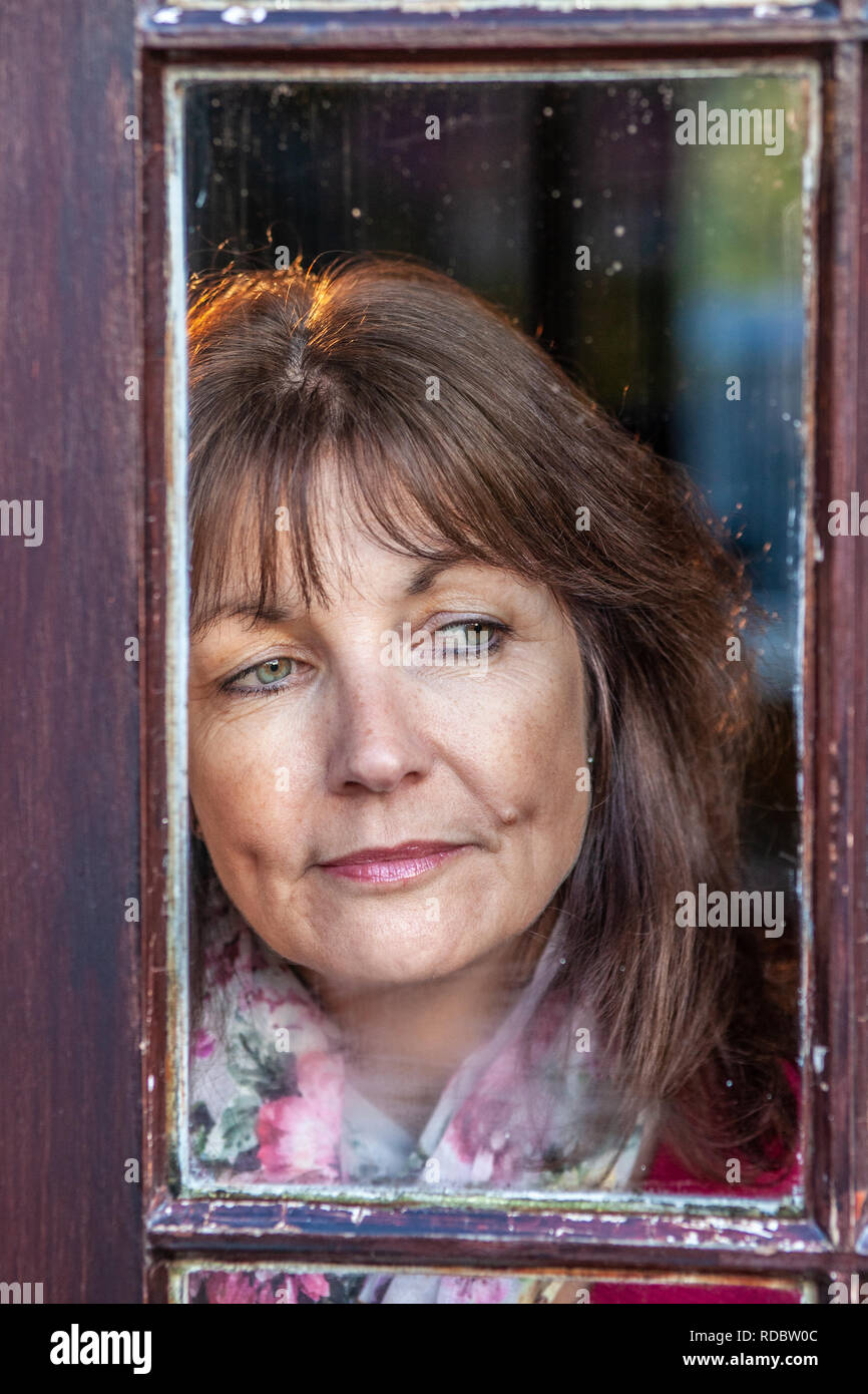 attractive, single woman, looking out of a window Stock Photo - Alamy