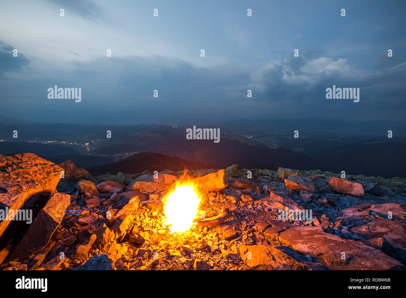 Beautiful summer night in mountains. Bright white yellow fire burning ...