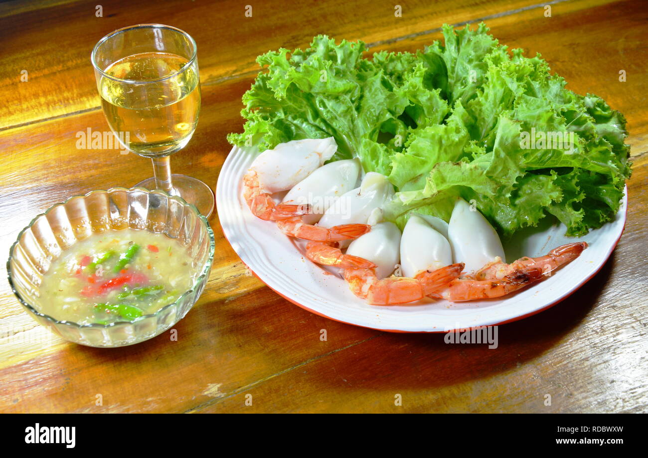 prawn stuffed squid cocktail dipping with spicy sauce and sparking ...