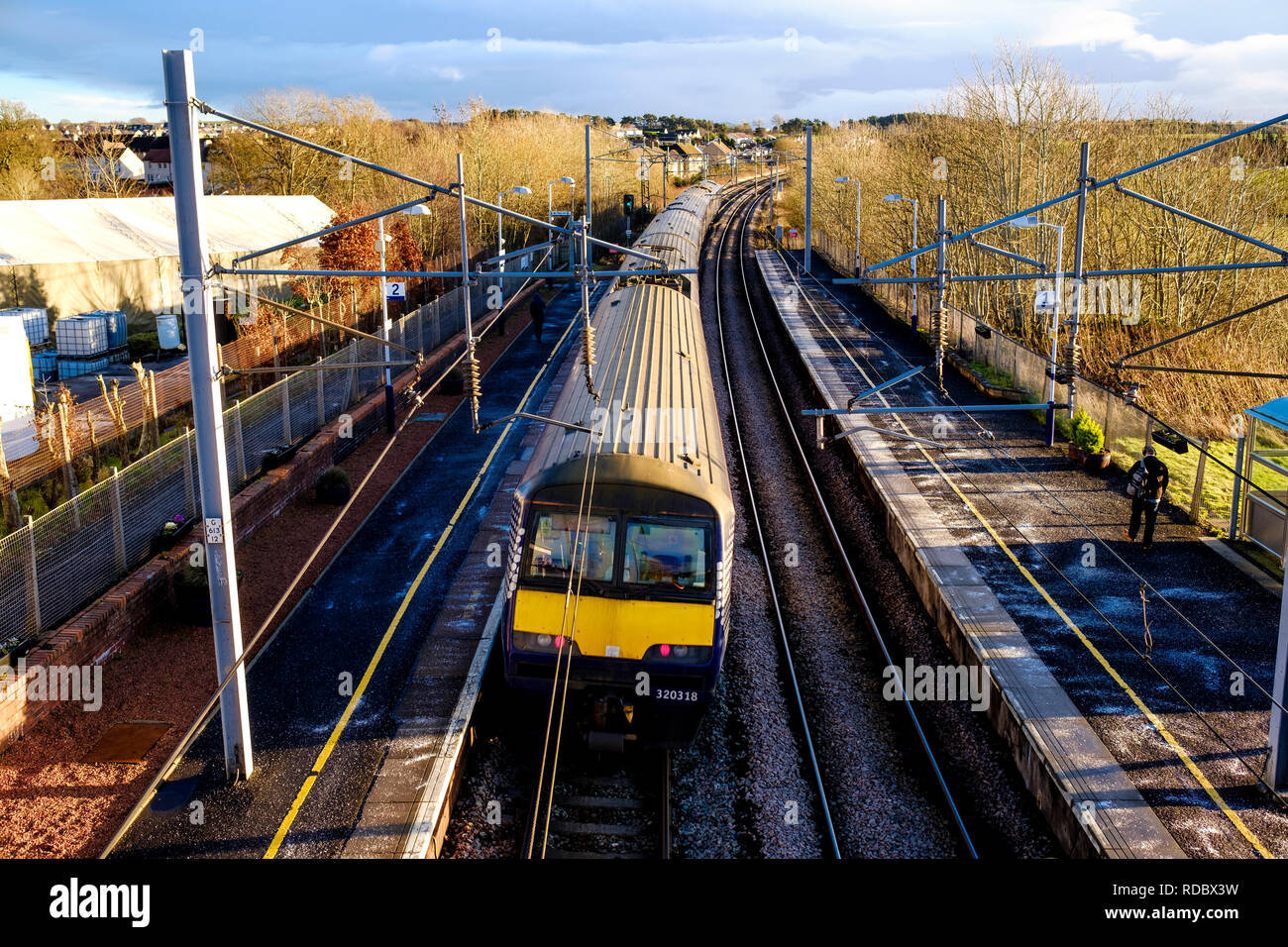 A commuter train leaving Carluke station in South Lanarkshire, Scotland ...