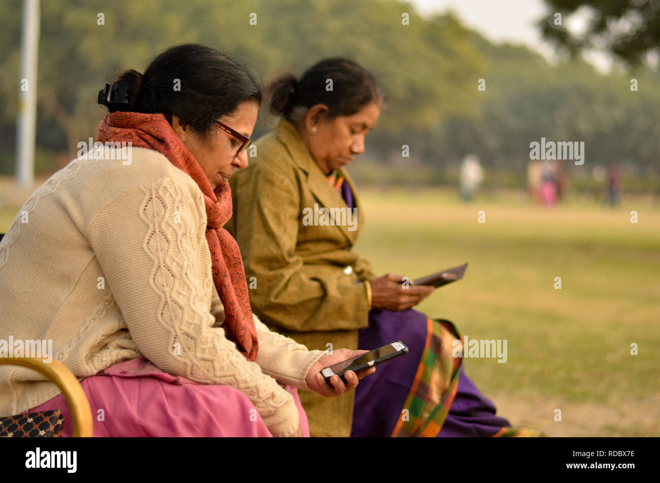 North and south Indian senior old women using technology busy on their ...