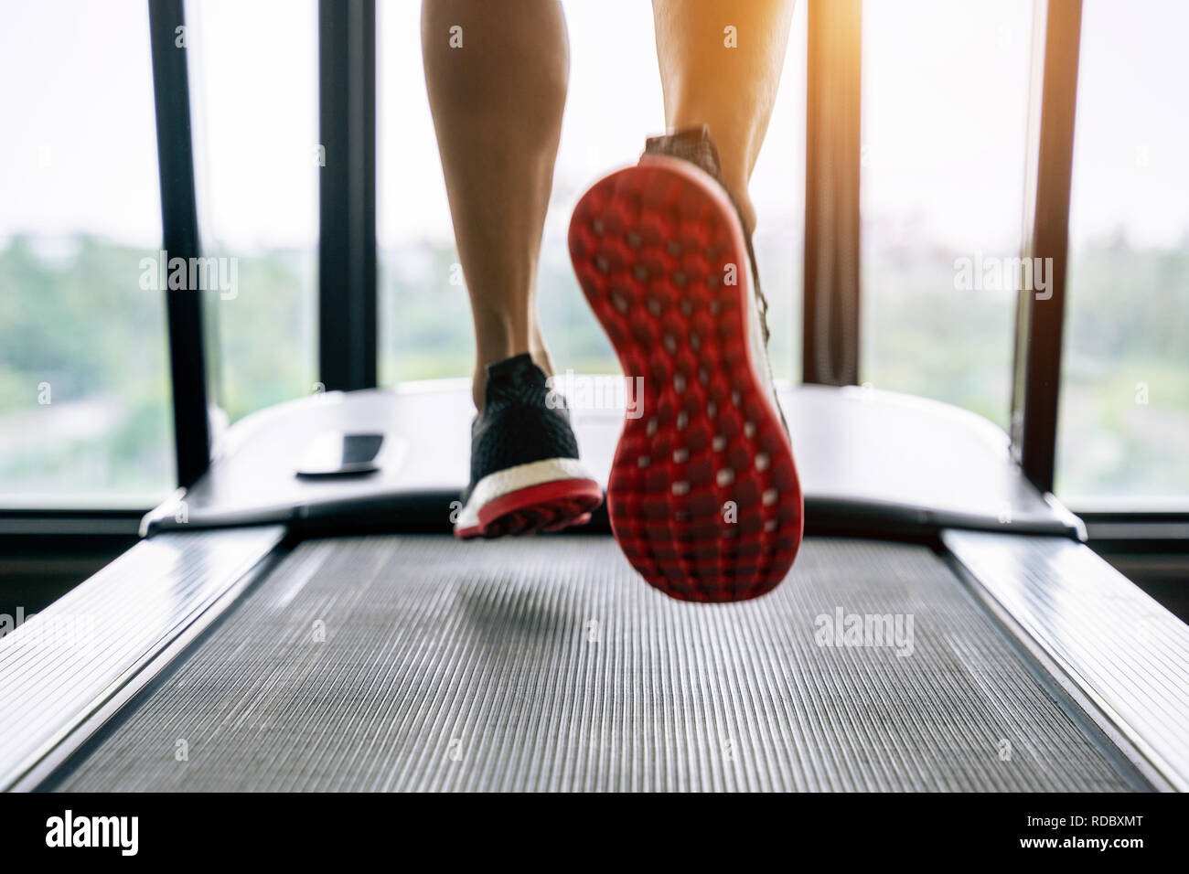Male feet in sneakers running on the treadmill at the gym. Exercise ...