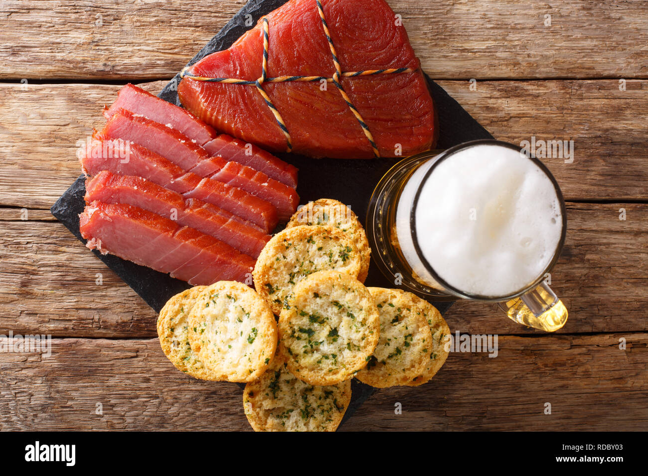 Foamy beer served with smoked tuna and toast with garlic and greens ...