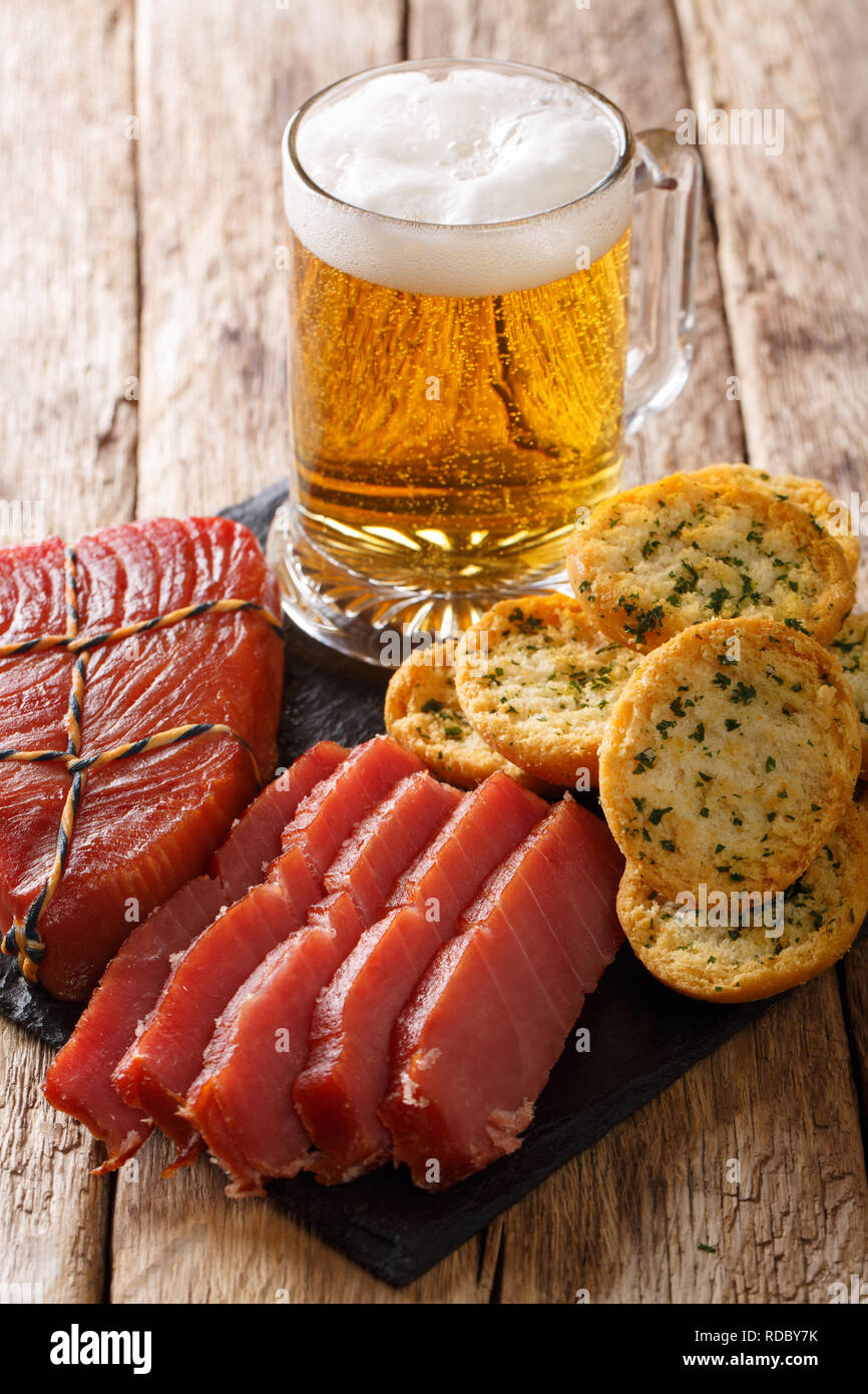 Golden beer glass served with smoked tuna and toasts with garlic and ...