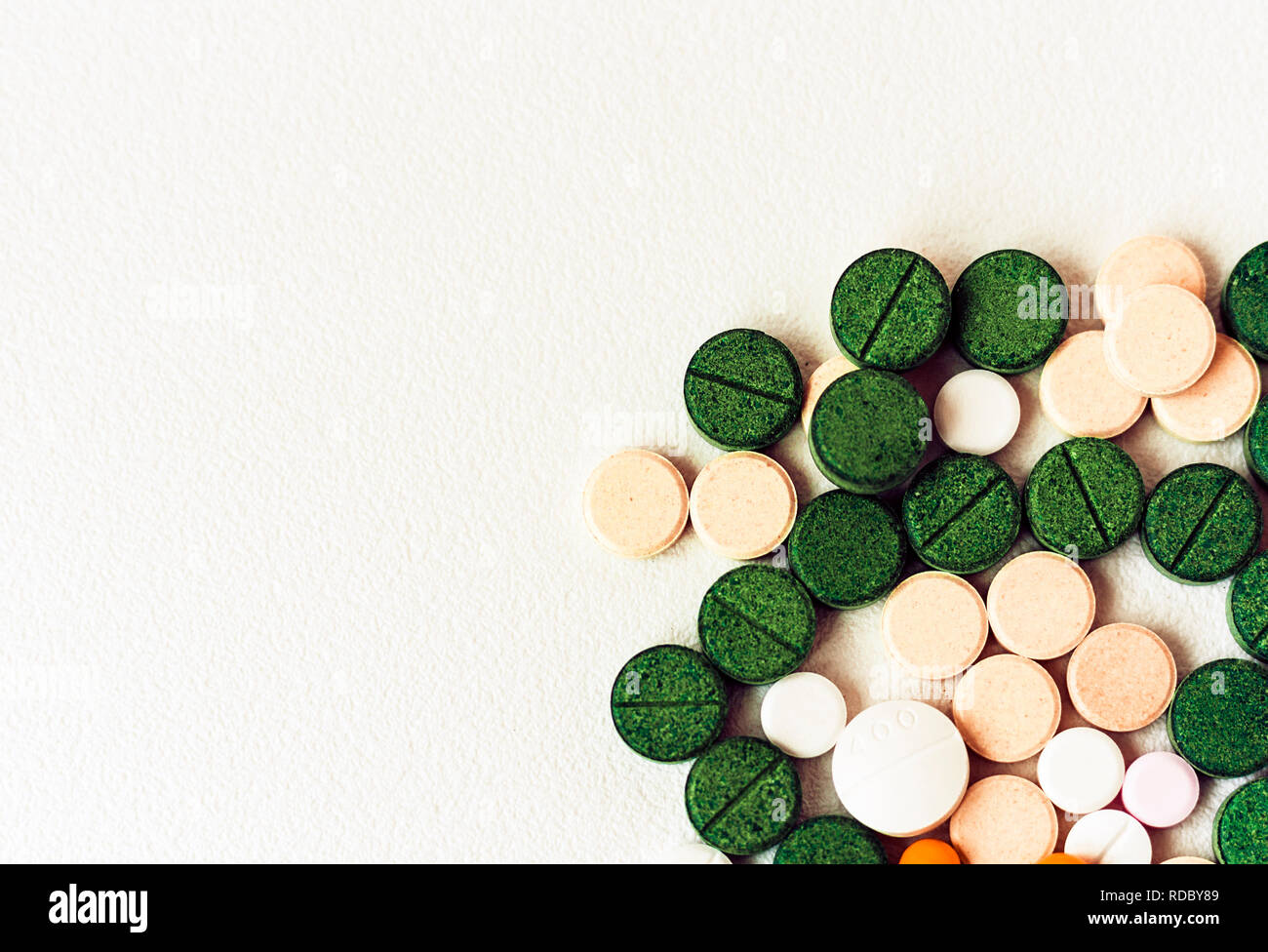 Medicine green, pink and yellow pills or capsules on white background ...