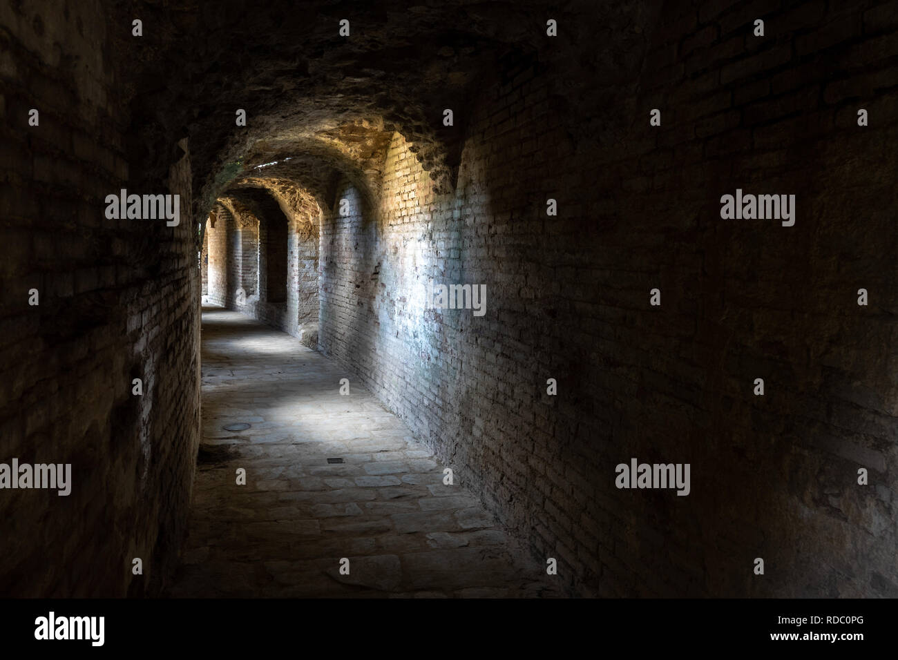 Curved stone tunnel with sun light beams and curved roof Stock Photo ...