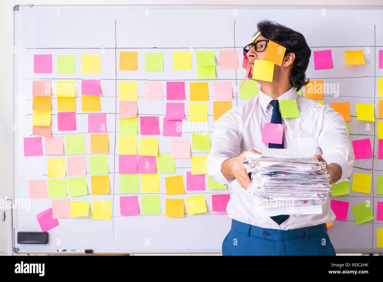 Young employee in conflicting priorities concept Stock Photo - Alamy