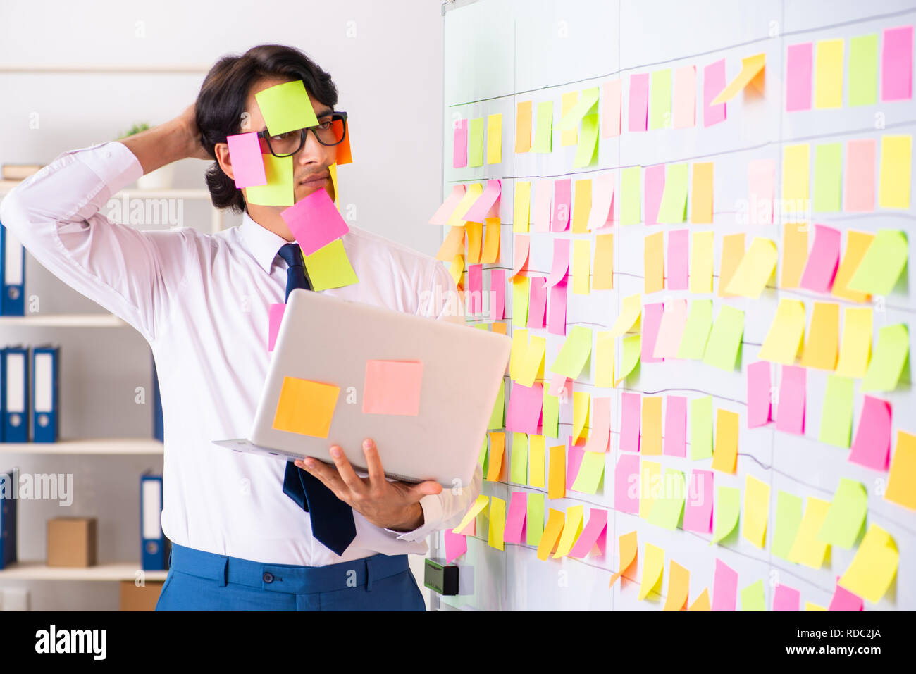 Young employee in conflicting priorities concept Stock Photo - Alamy