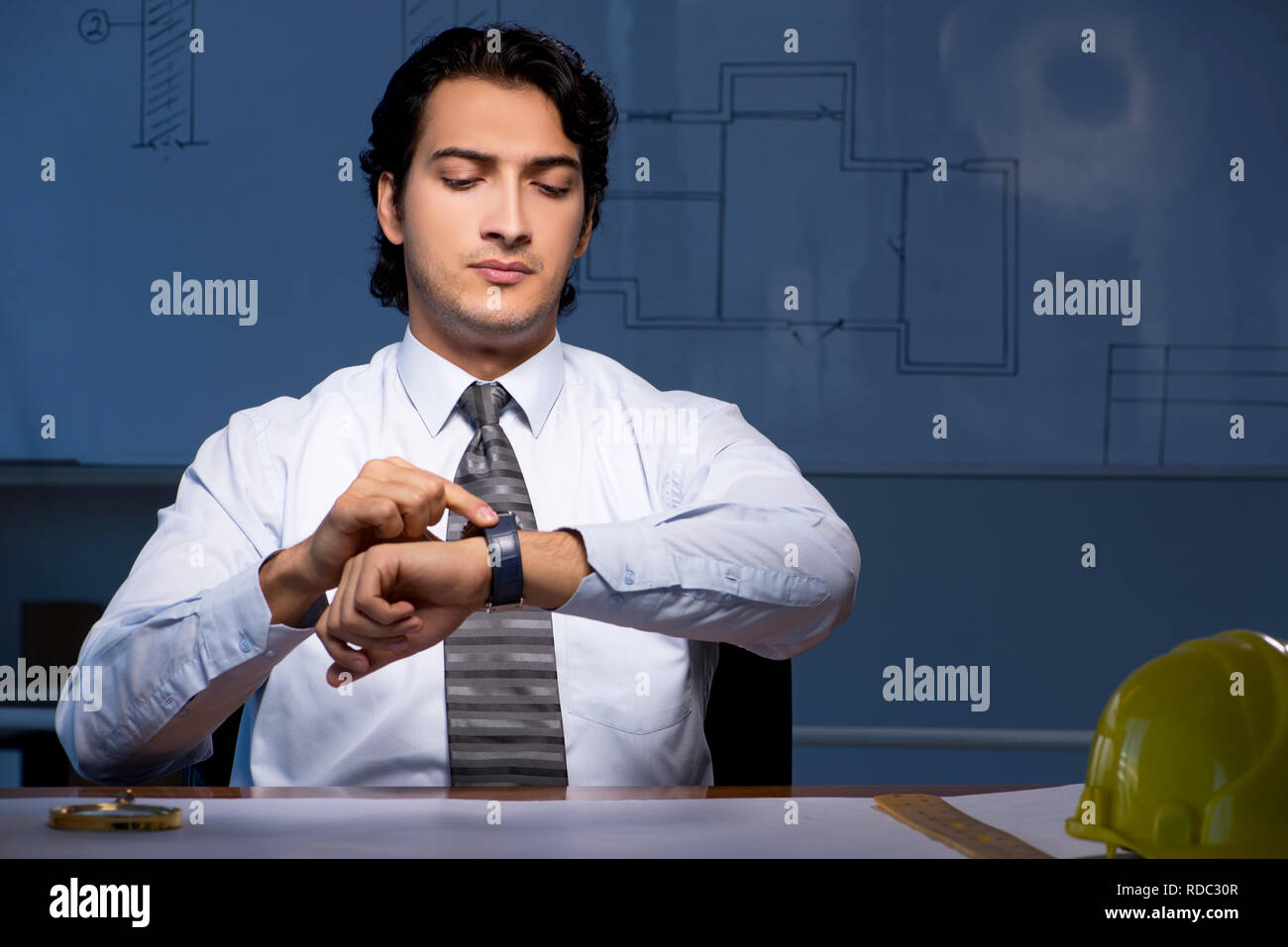 Young construction architect working on project at night Stock Photo ...