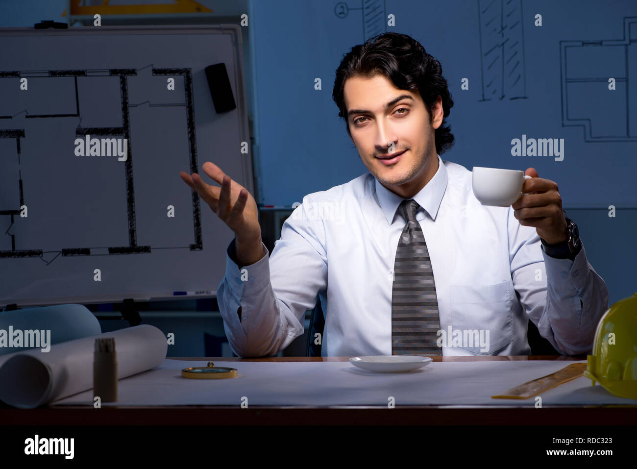 Young construction architect working on project at night Stock Photo ...