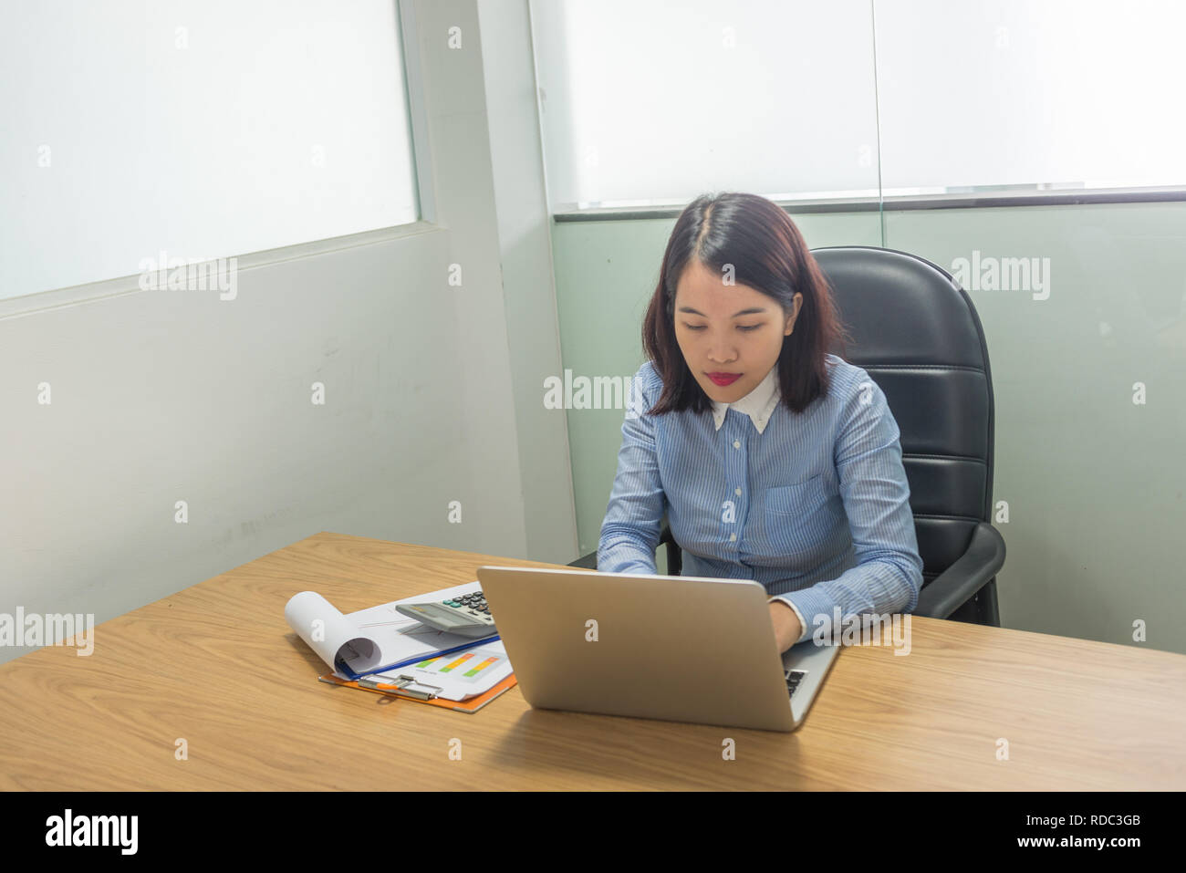 Asian employee working on laptop Stock Photo - Alamy
