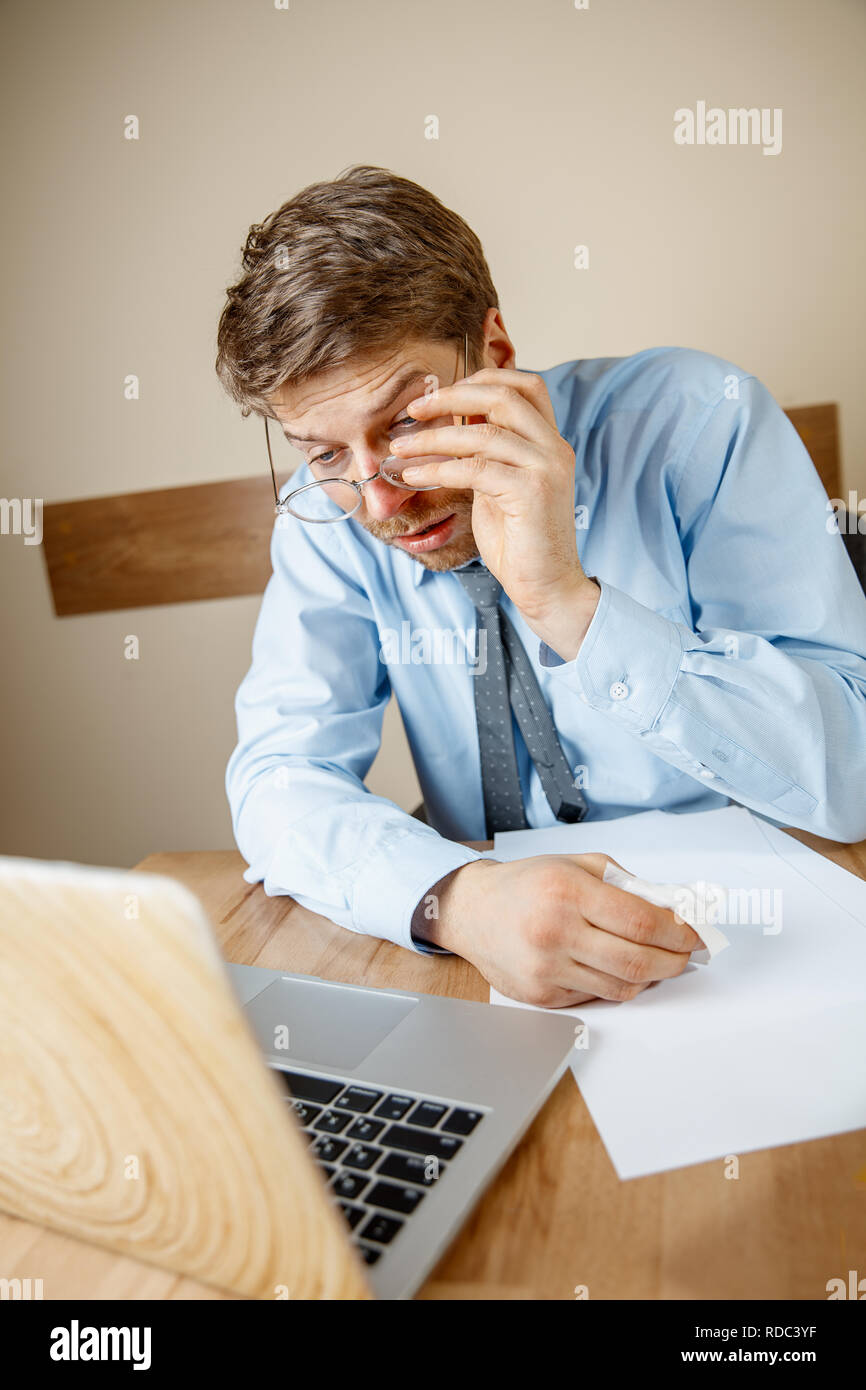 Feeling sick and tired. Frustrated sad unhappy sick young man sitting ...