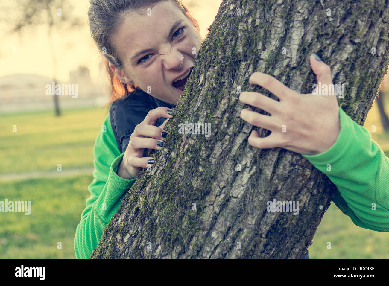 Female clawing at tree trunk raising environmental awareness. Climate ...
