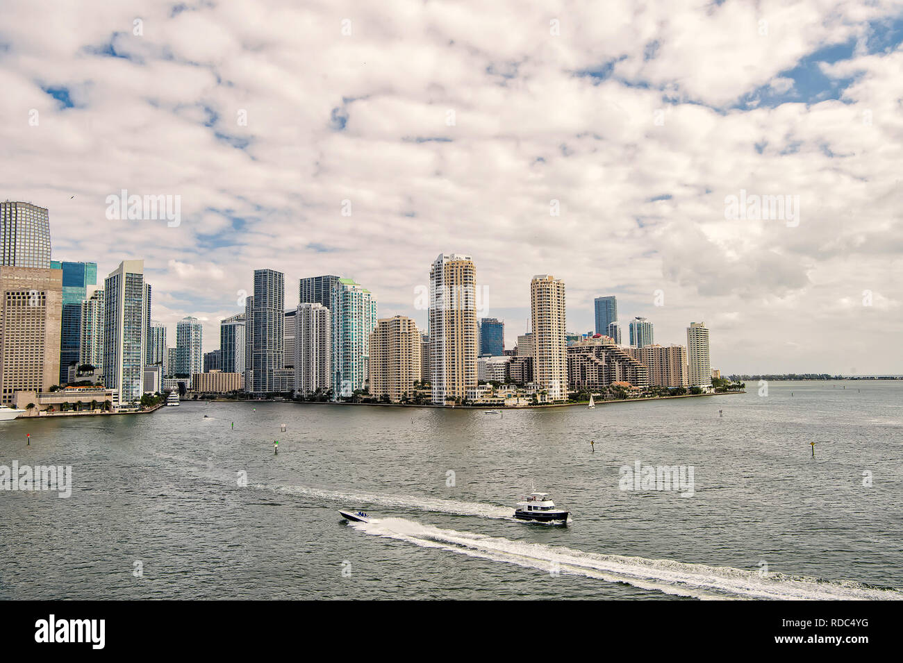 Miami skyscrapers with blue cloudy sky,white boat sailing next to Miami ...