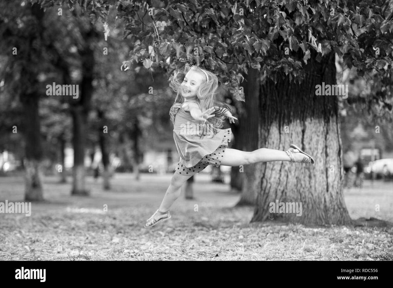 happy childhood. Little girl dancer jump in summer park. Child dance in ...