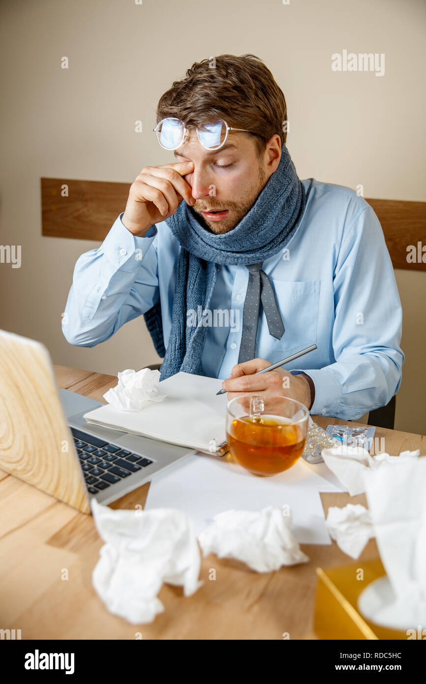 Feeling sick and tired. Frustrated sad unhappy sick young man massaging ...