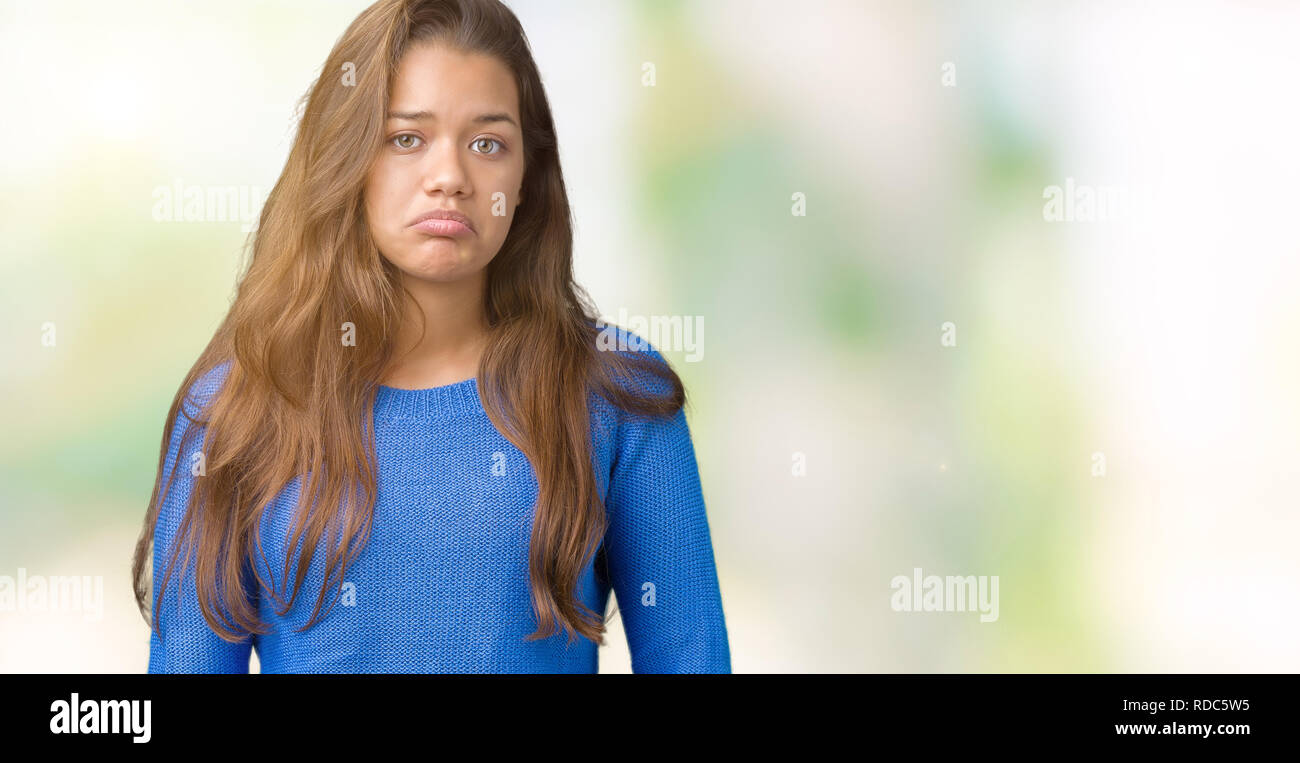 Young beautiful brunette woman wearing blue sweater over isolated ...